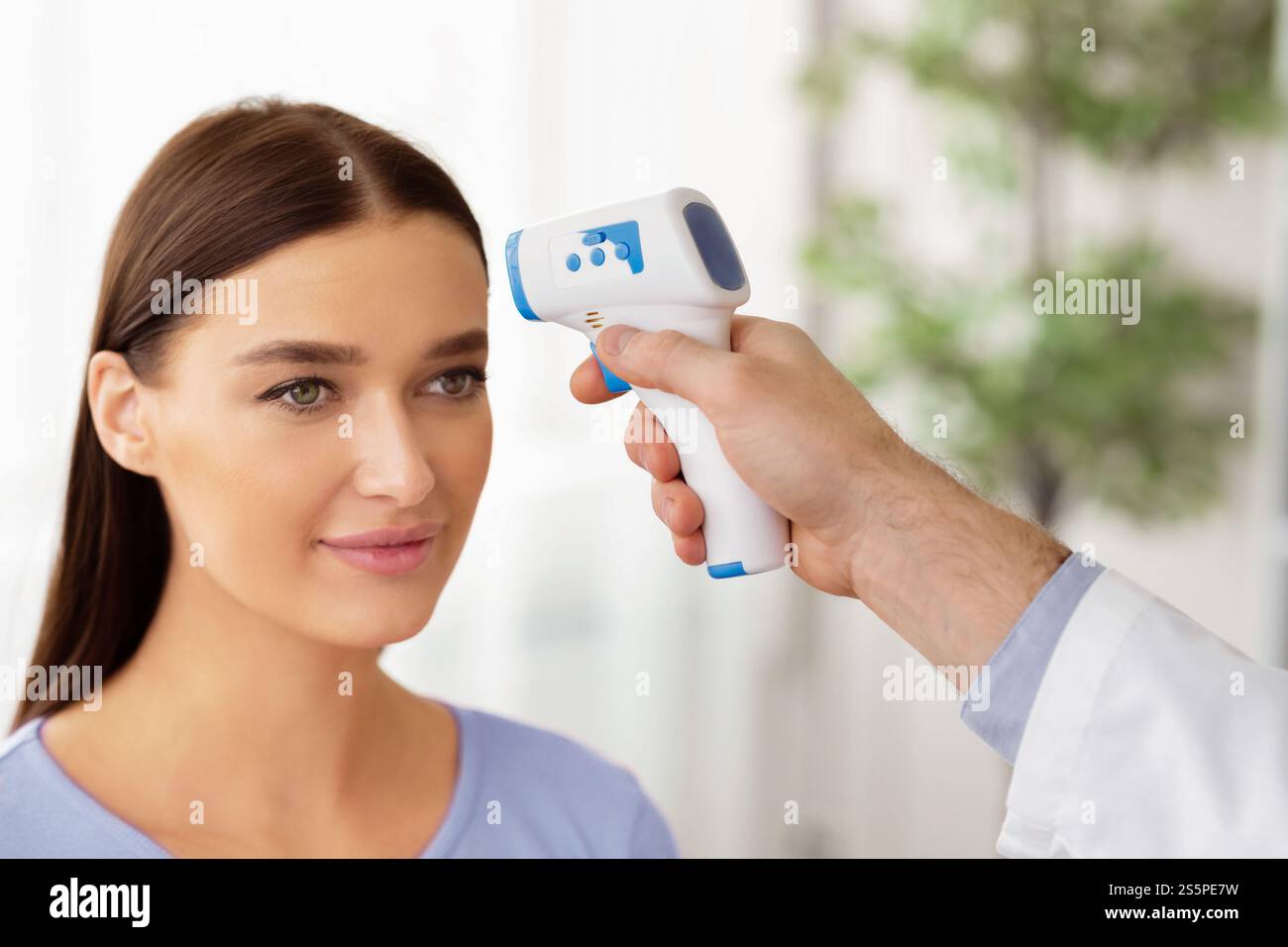 Doctor checking temperature of patient using infrared thermometer Stock ...