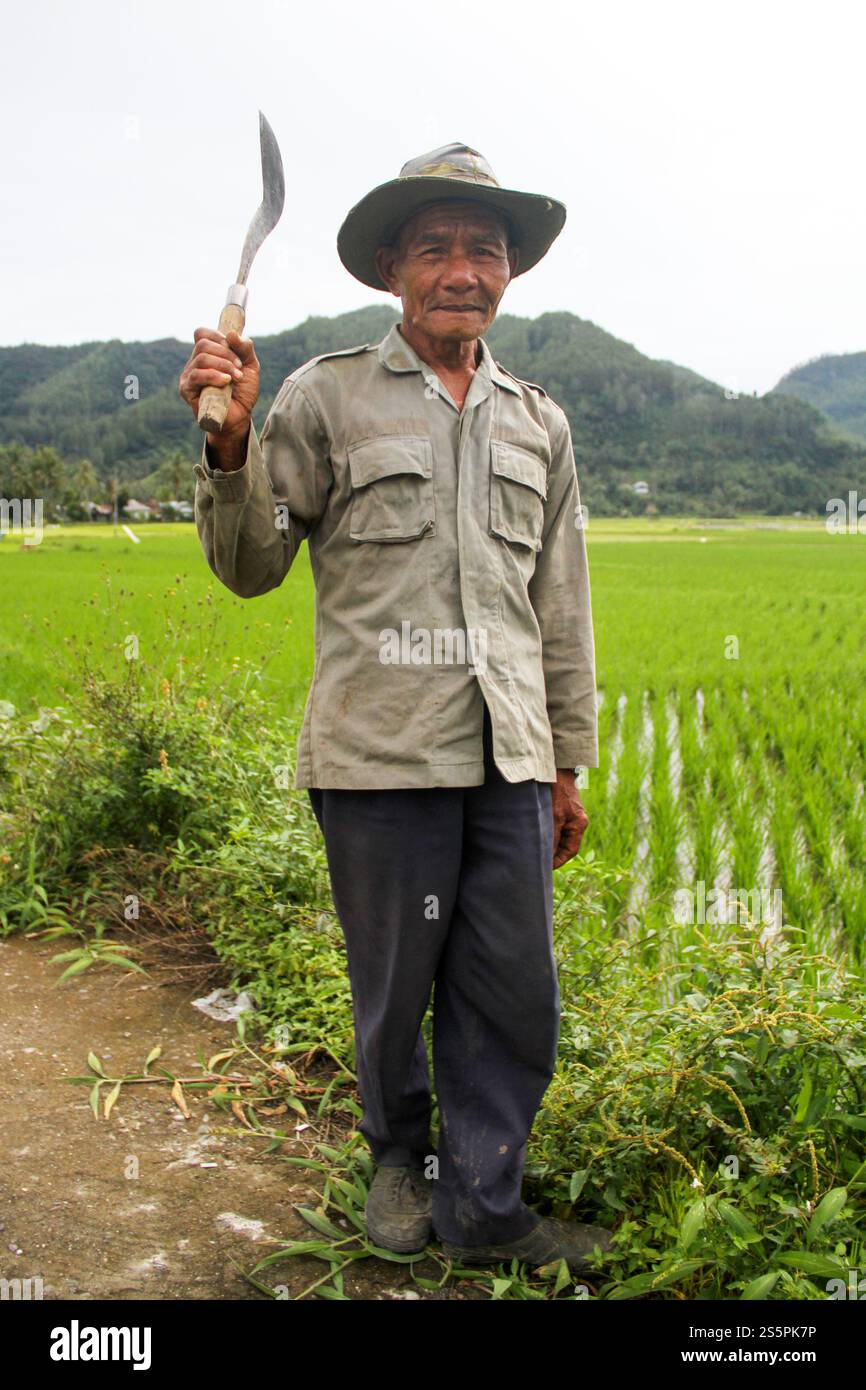 Indonesian rice farmer carrying a hoe in the Harau Valley of West ...