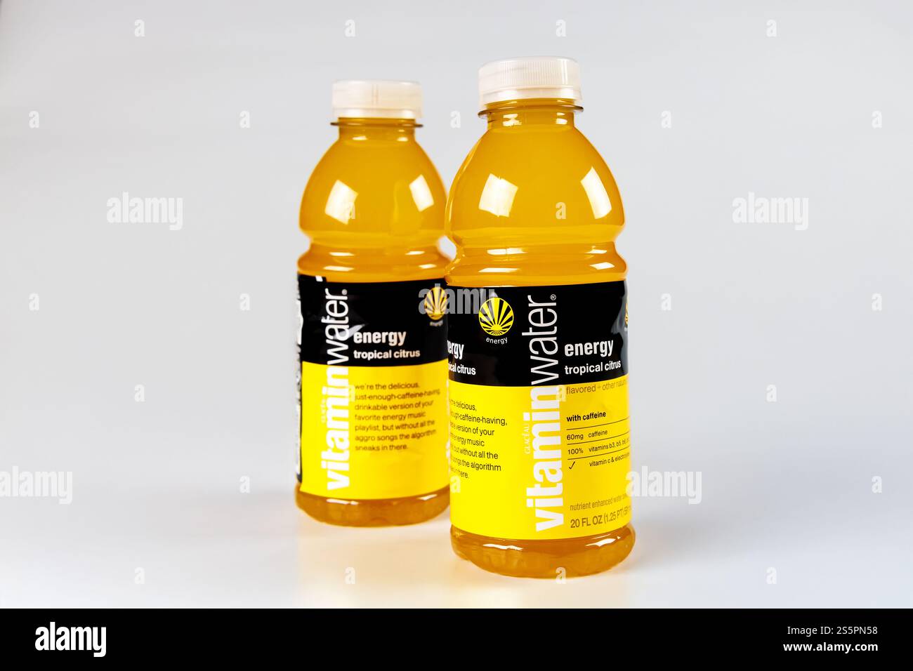 Bright tropical citrus energy drink bottles positioned on plain ...
