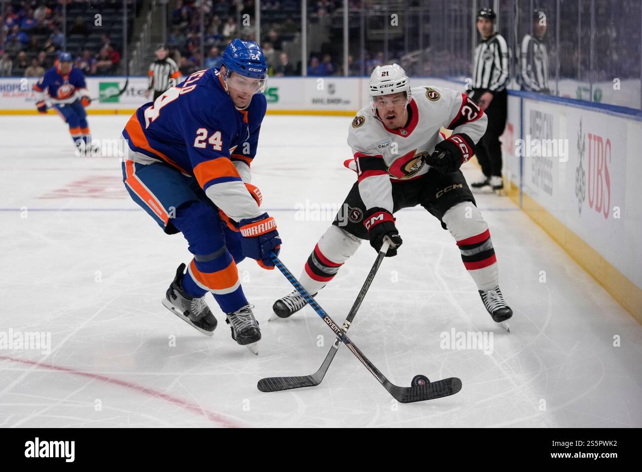 New York Islanders' Scott Mayfield (24) fights for control of the puck ...