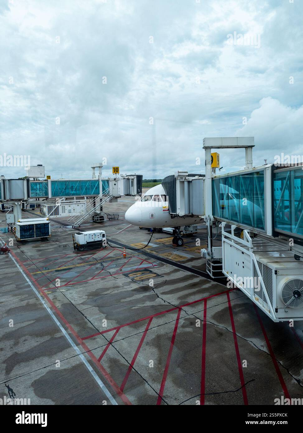 A passenger airplane docked at gate 9 with an extended boarding bridge ...