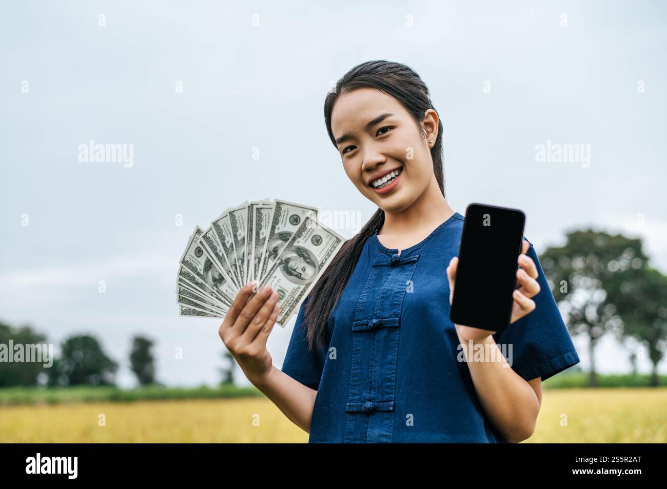 Portrait of asian young farmer woman holding money dollar banknotes and ...