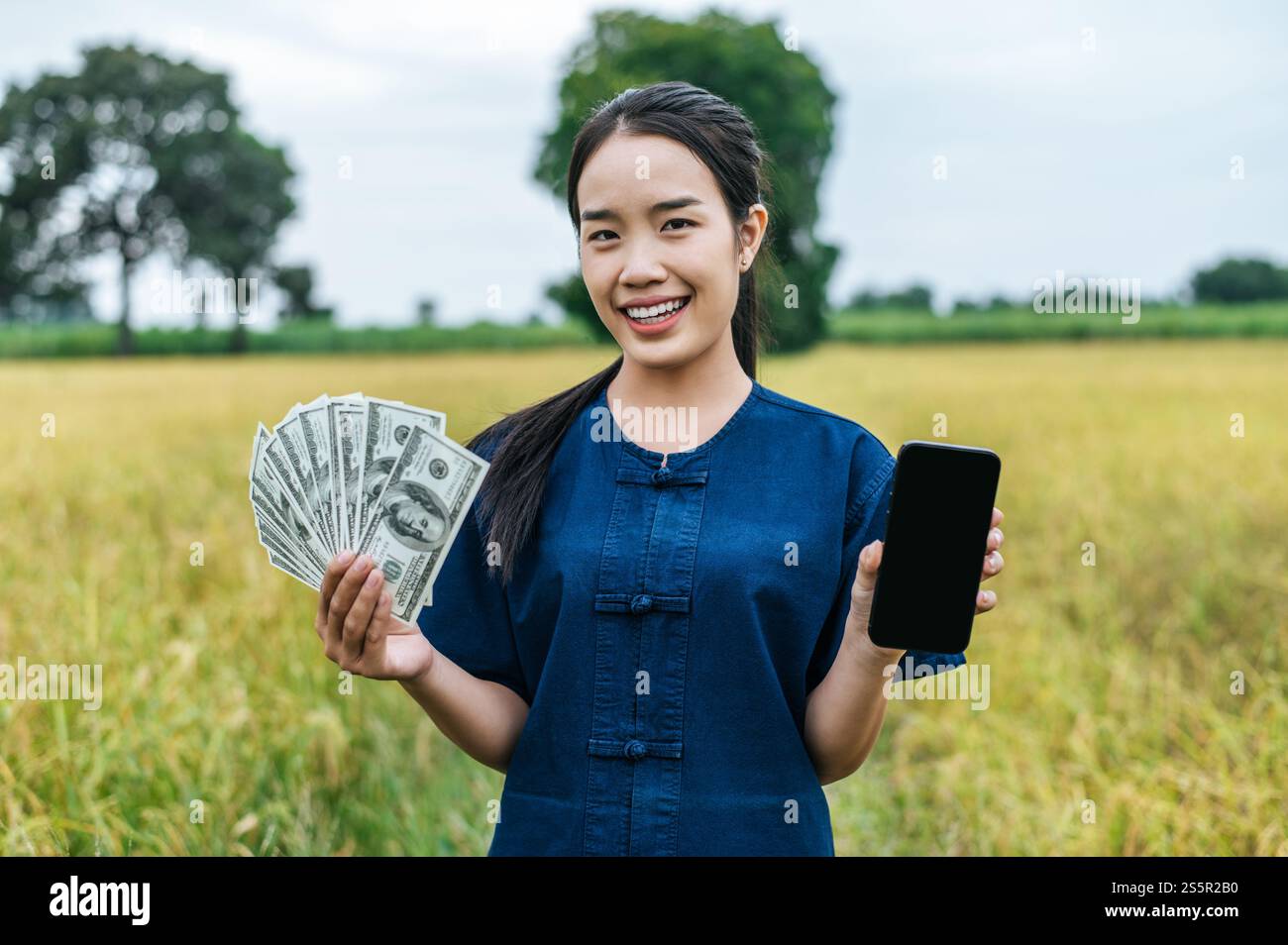 Portrait of asian young farmer woman holding money dollar banknotes and ...