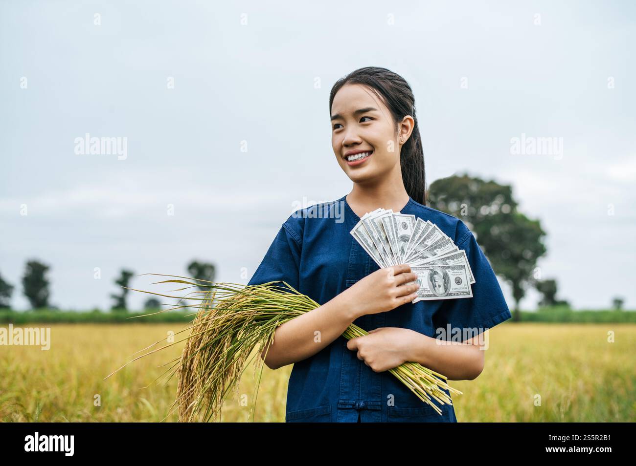 Portrait of asian young farmer woman holding money banknotes and ripe ...
