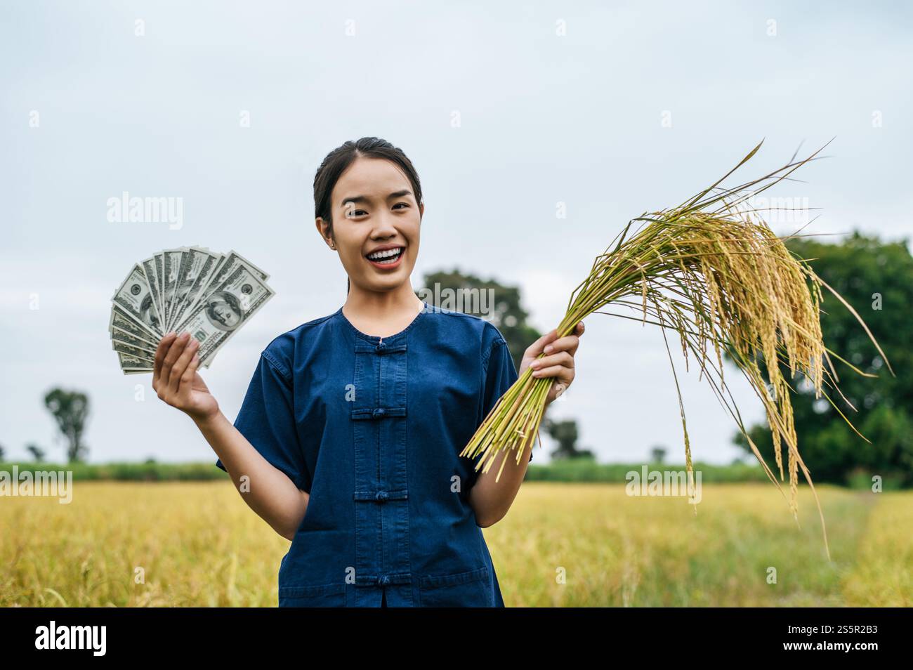 Portrait of asian young farmer woman holding money banknotes and ripe ...
