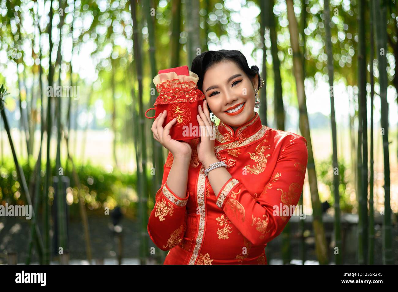 Portrait pretty Asian woman in a Chinese cheongsam holding envelopes in ...