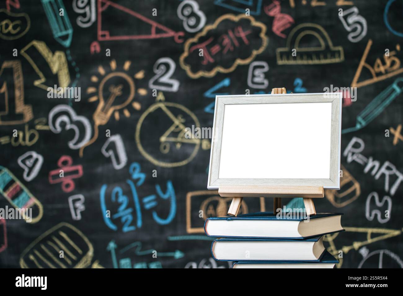 white photo frame on the stand and colored pencils on the books in ...