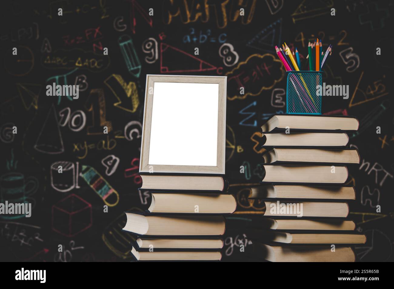 white photo frame and colored pencils on books in classroom Stock Photo ...