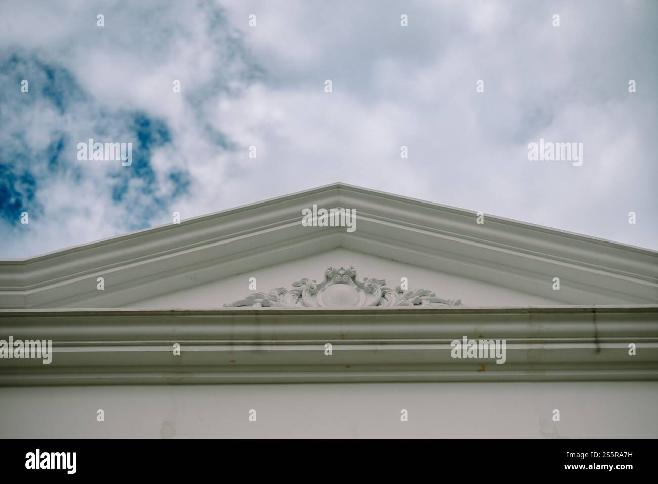 White triangular pediment with ornate details against a blue sky Stock ...
