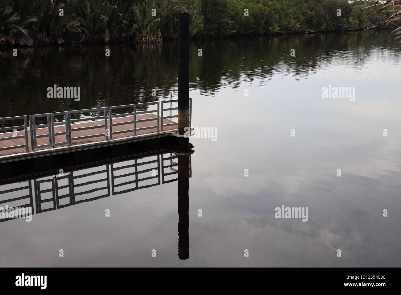 simple dock pier reflected in placid calm river water Stock Photo - Alamy