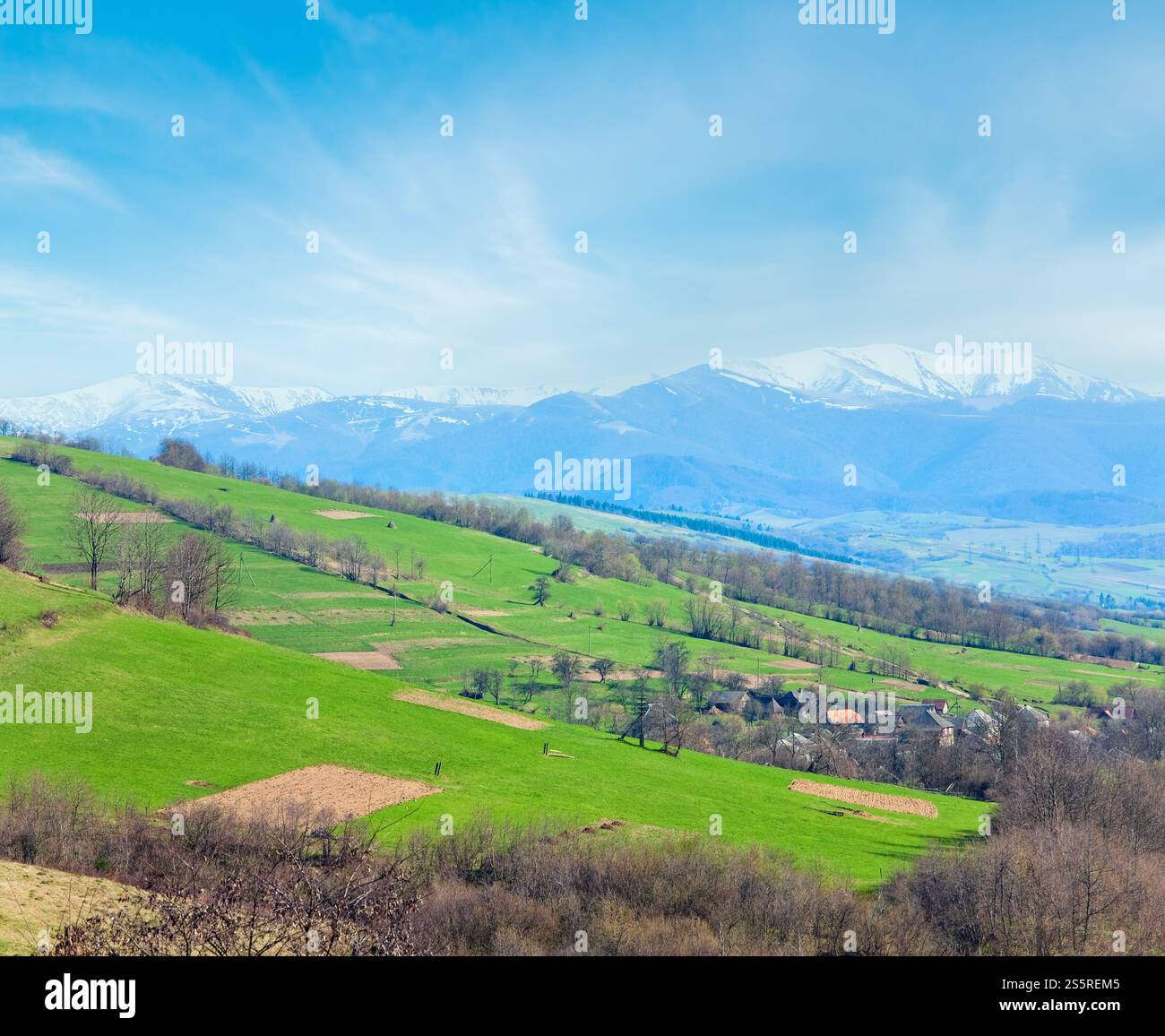 Spring mountain country valley view with farm fields and mountains in ...