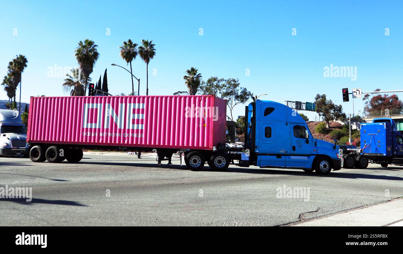 Freight Truck carrying an ONE Ocean Network Express shipping container on a street toward the ...