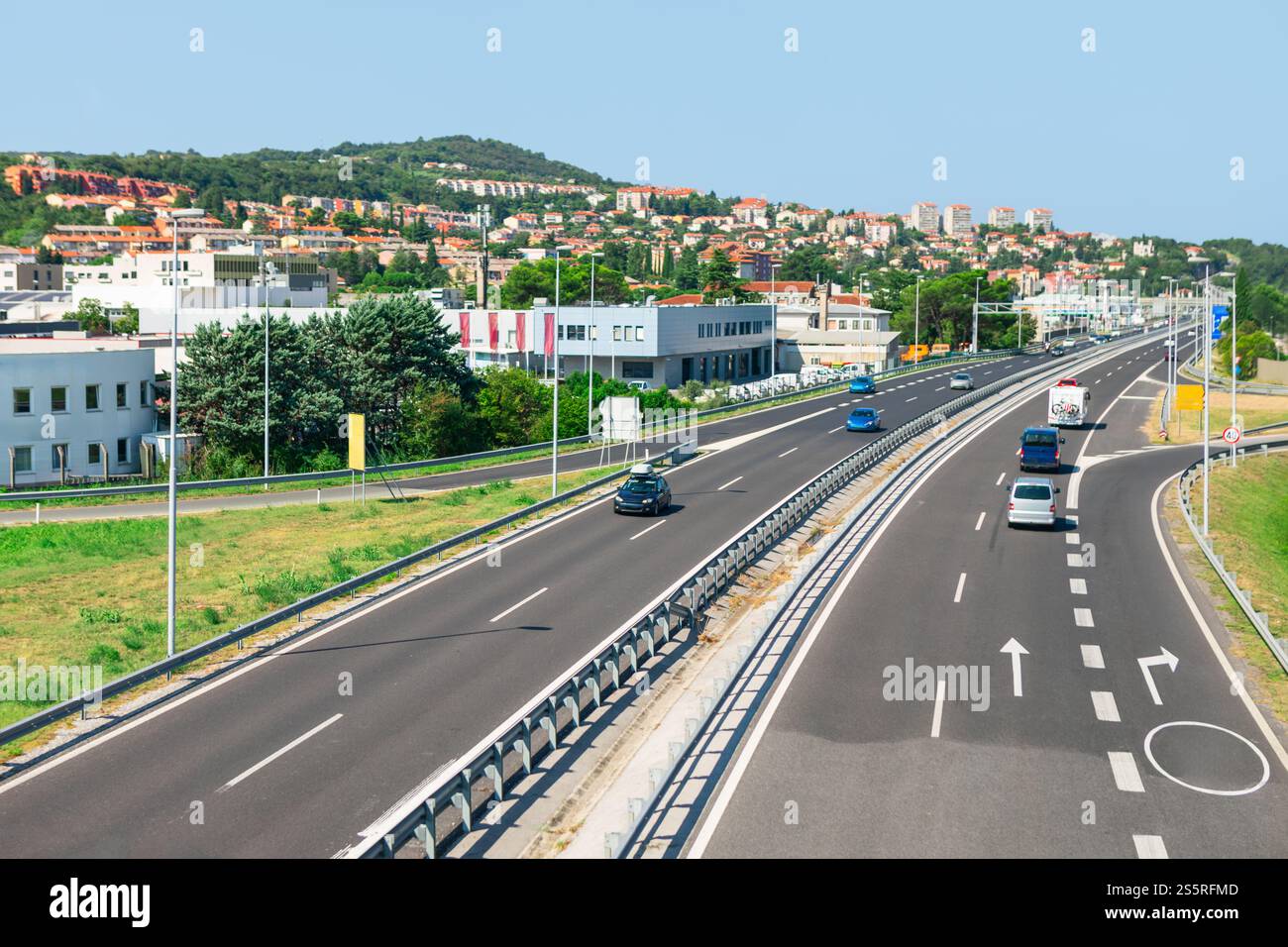 Modern highway with multiple lanes, surrounded by green landscapes and ...