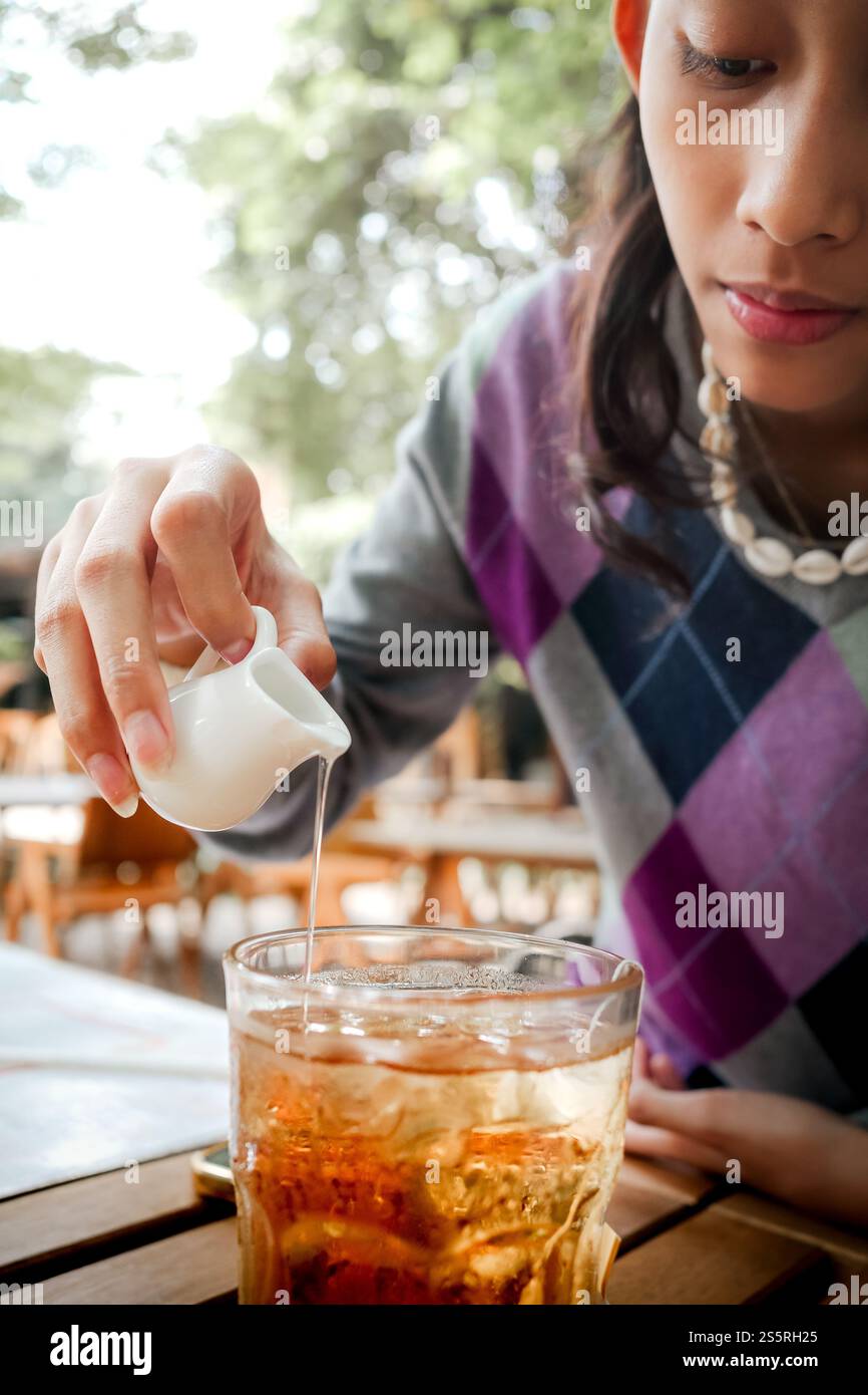 Asian teenage girl pour liquid sugar to a glass of iced tea Stock Photo ...
