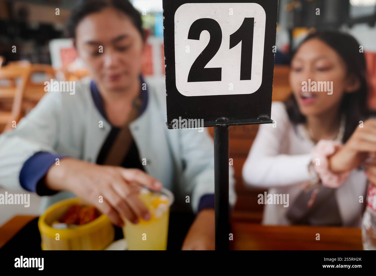 Asian family at a restaurant, with ordered food and drink at designated ...