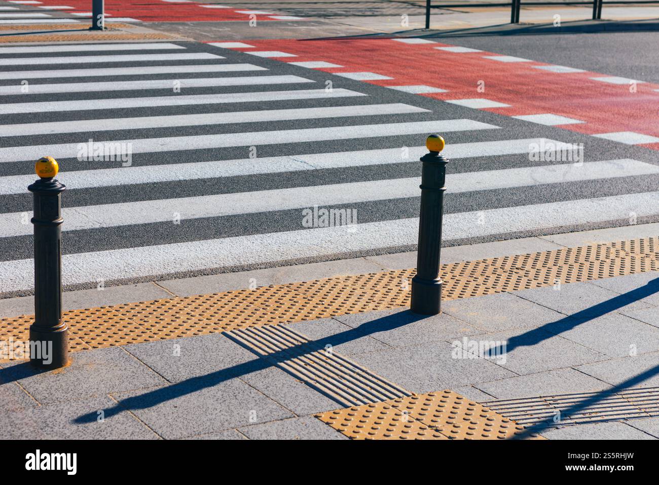 Urban crosswalk with bold white and red stripes, tactile paving for ...