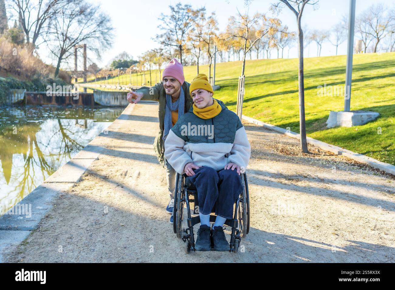 Two friends enjoying a walk in the park, one pushing the other in a ...