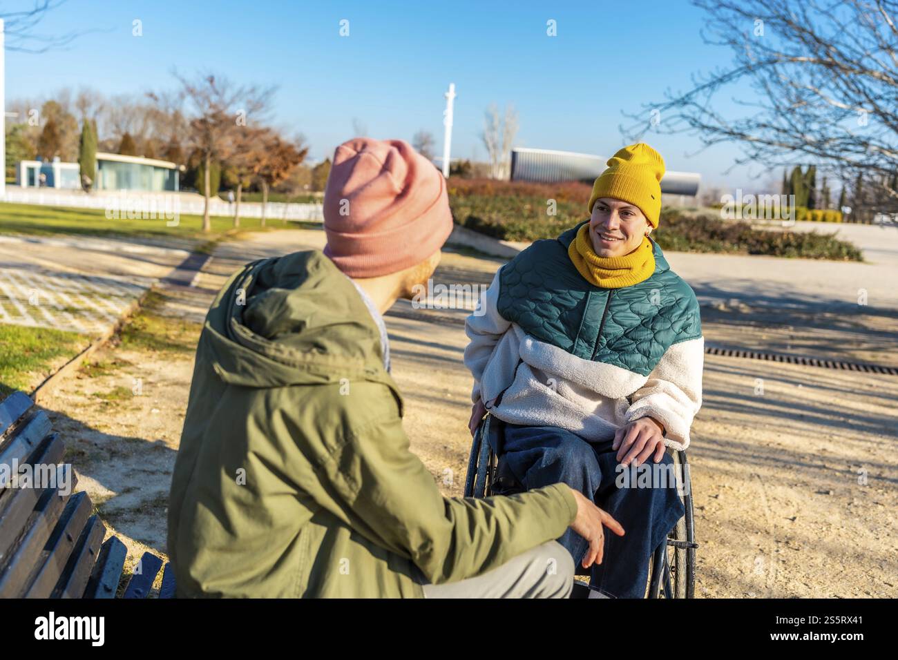 Two friends enjoying a sunny day at the park, discussing and sharing ...