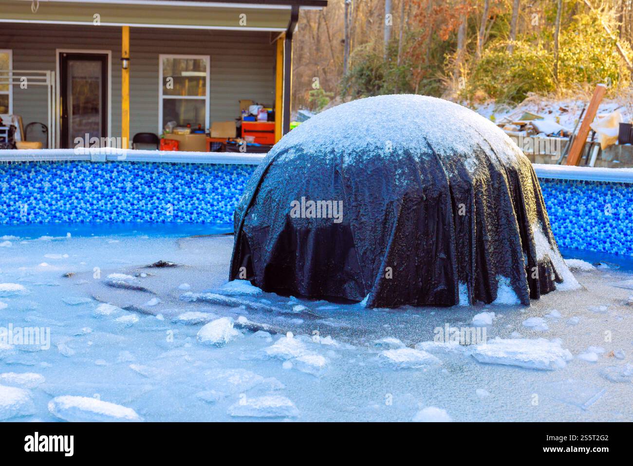 Black insulated dome sits atop frozen swimming pool surrounded by ice ...