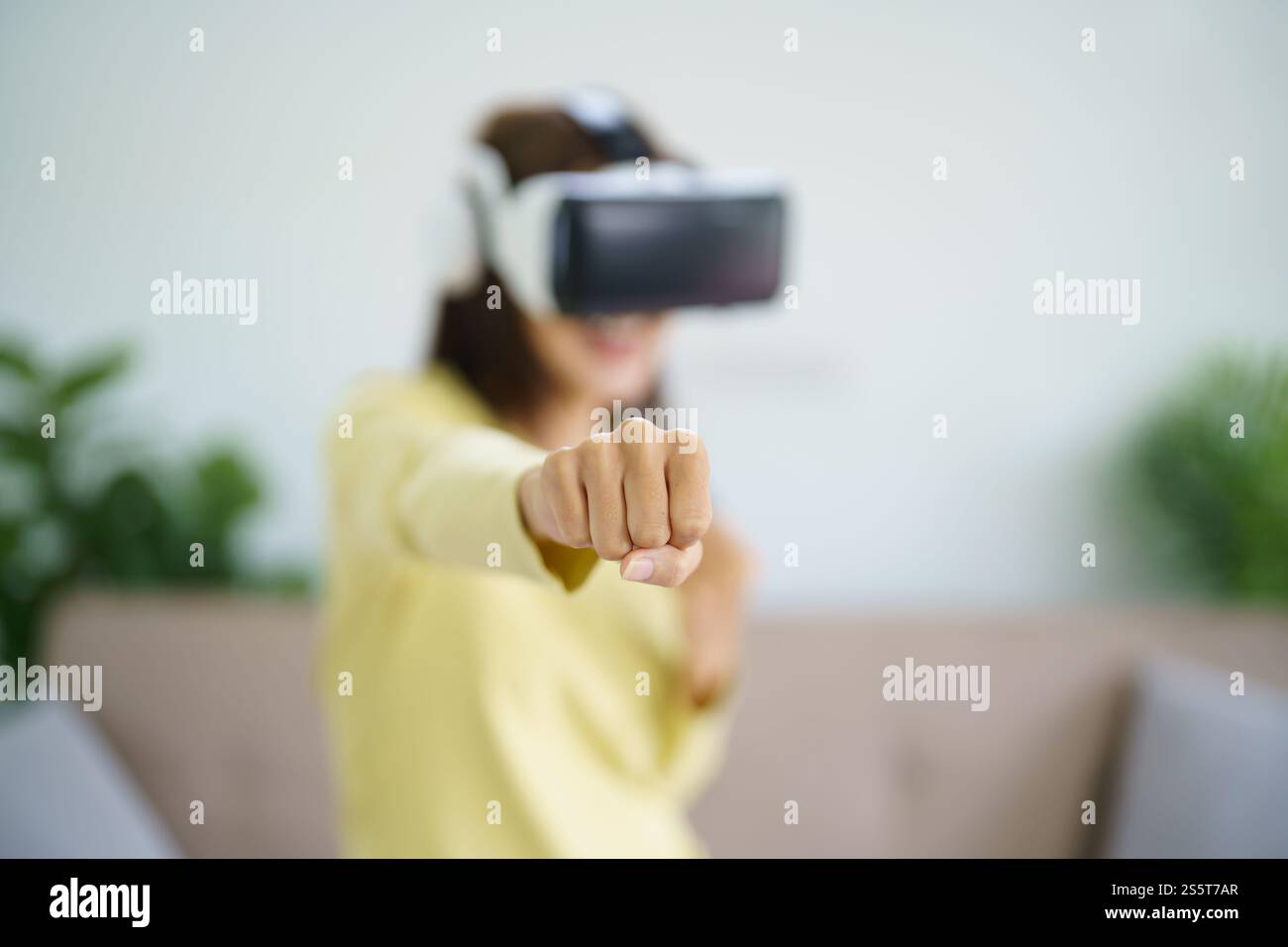 Young Asian woman gamer wearing virtual reality touching air during the ...