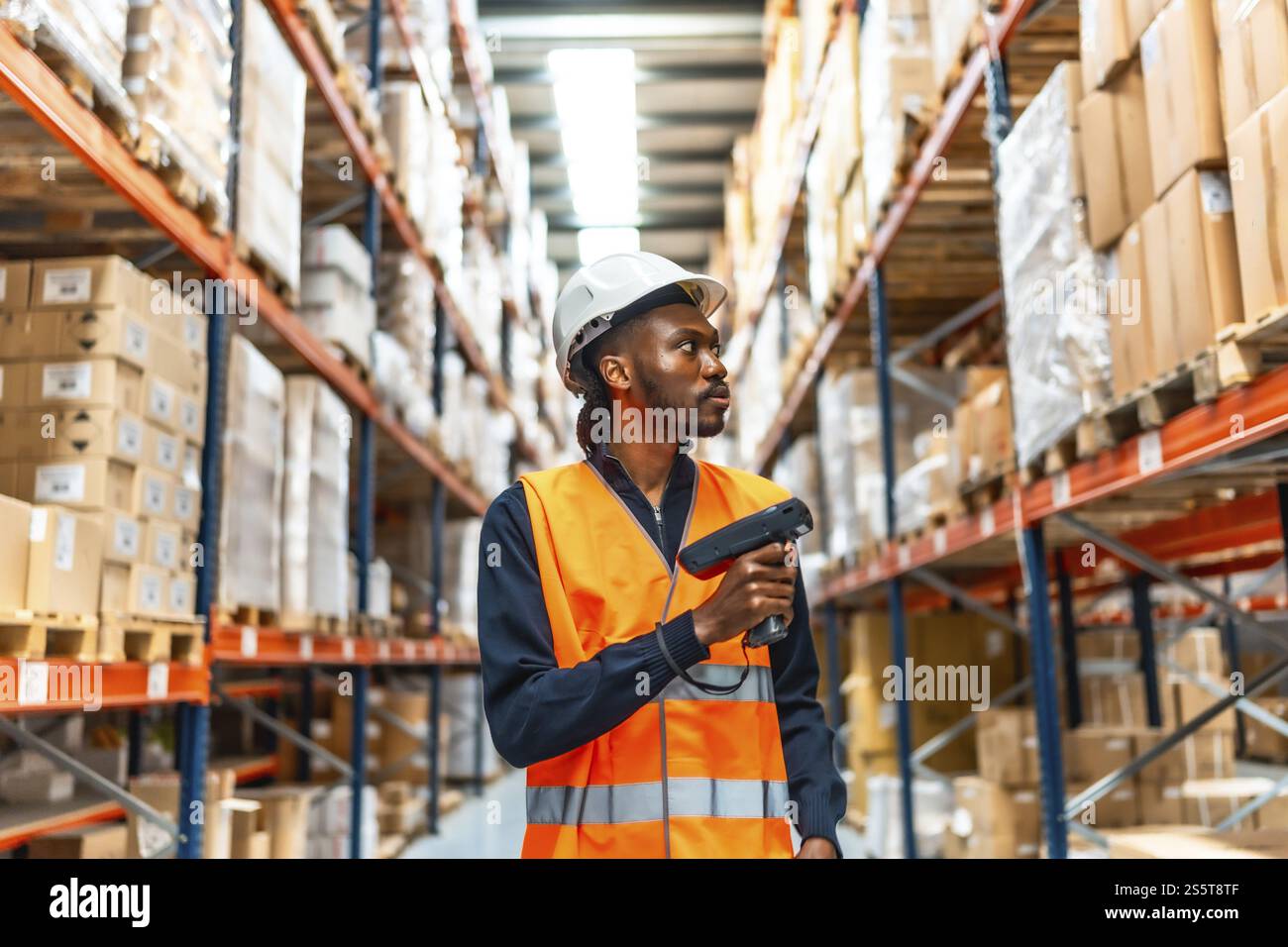 Frontal view of a concentrated african male worker using wireless ...