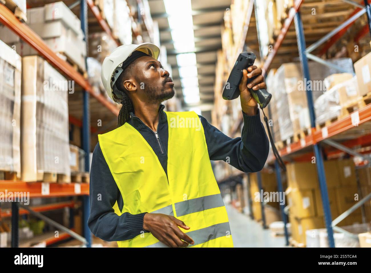 Frontal view of an african man scanning parcels in a distribution ...