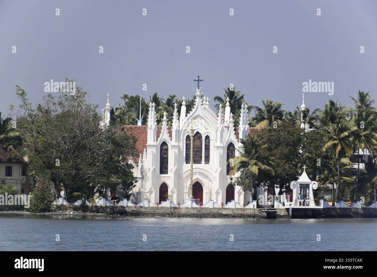 An impressive Gothic church with white towers and palm trees on the ...