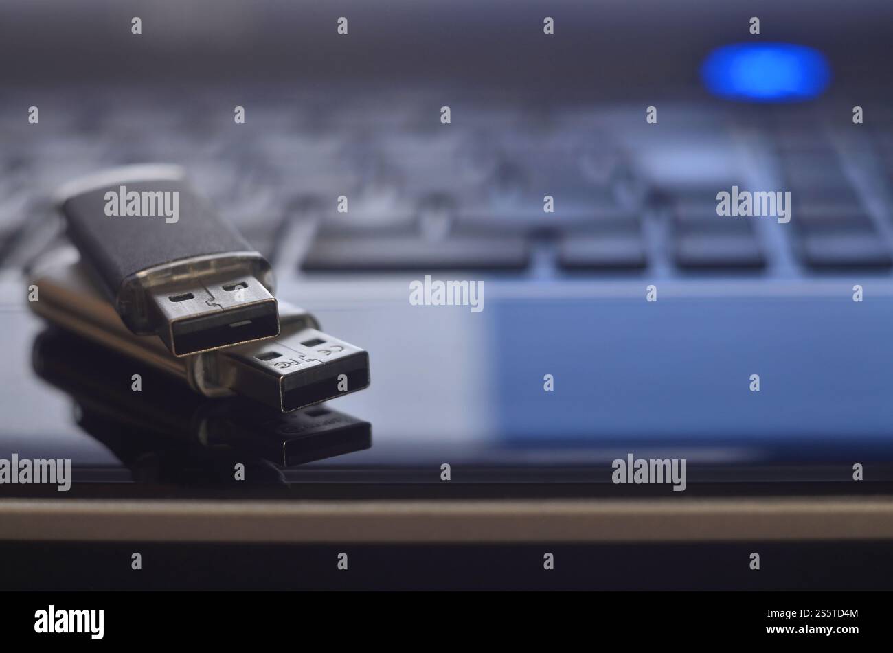 USB flash cards lying on black laptop case in front of his keyboard ...