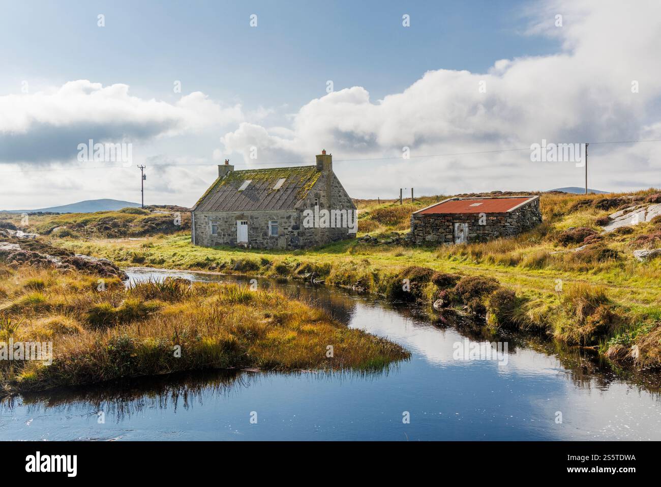 Scotland, Hebrides. Isle of North Uist. Traditional stone house by a ...