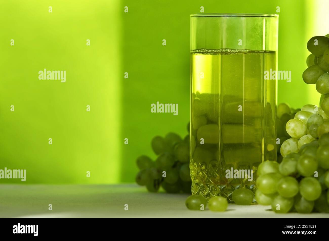 Yellow grape juice and wet bunches of green grapes. Green grape juice ...