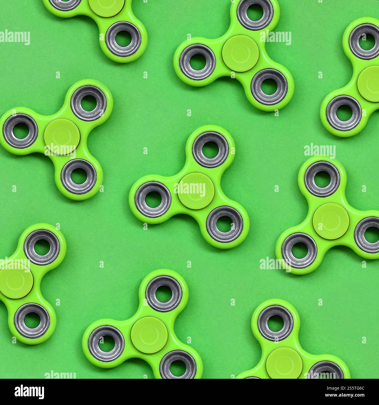 Many green fidget spinners lies on texture background of fashion pastel ...
