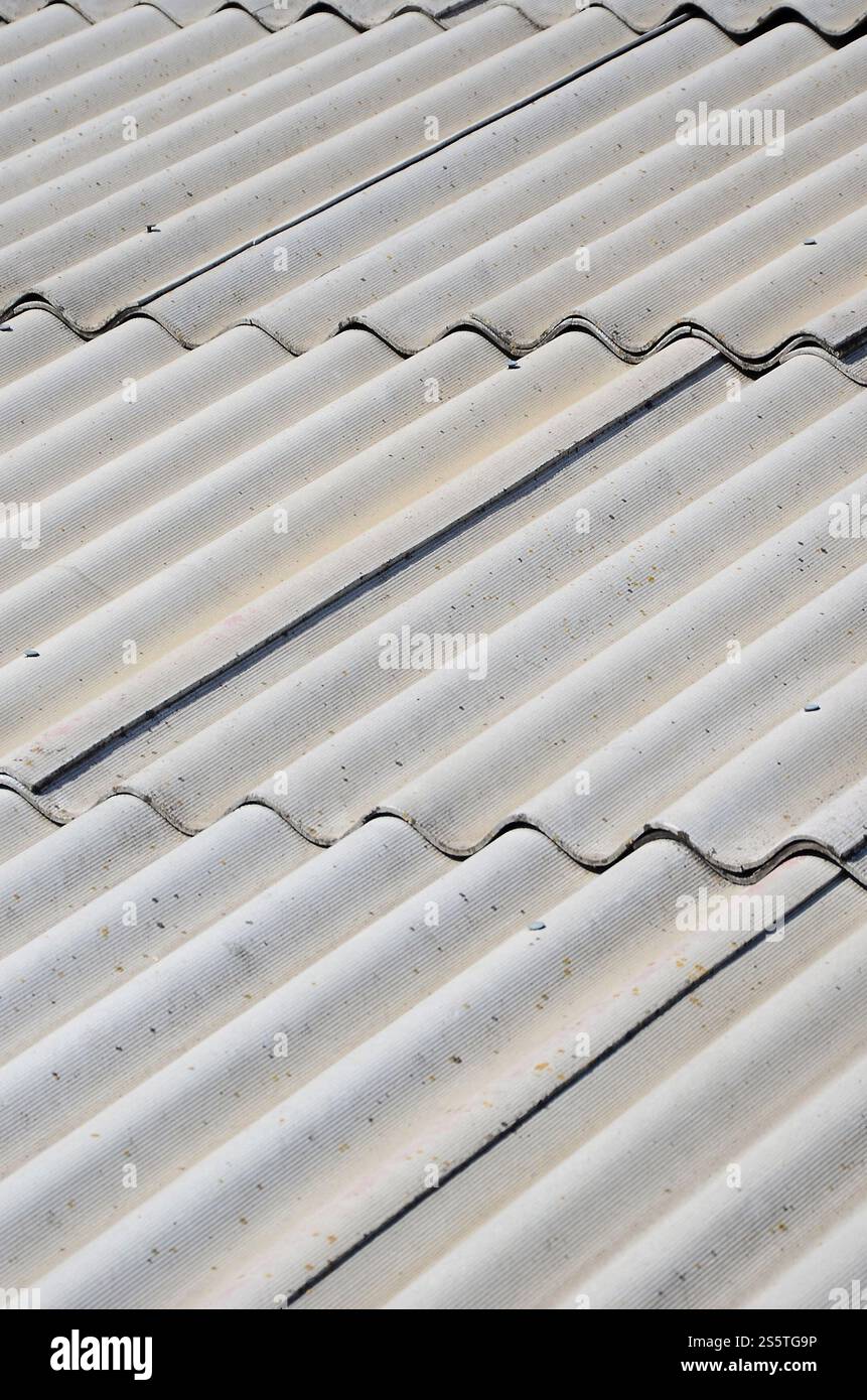 A fragment of a gray slate roof of an old sample made of asbestos ...