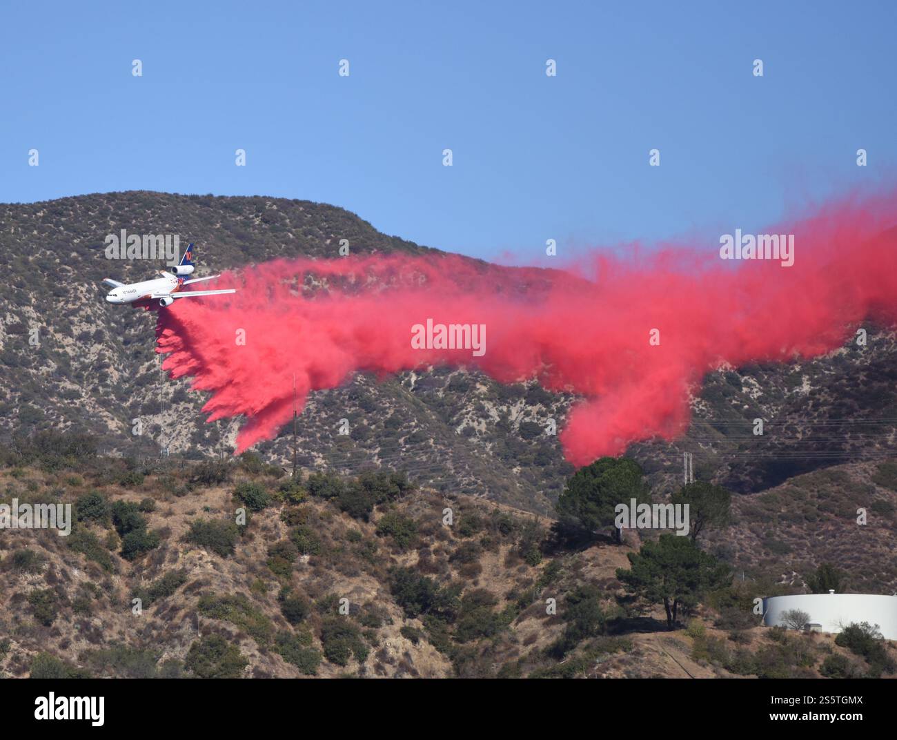 Los Angeles, USA.13th January 2025. A firefighting plane drops fire ...
