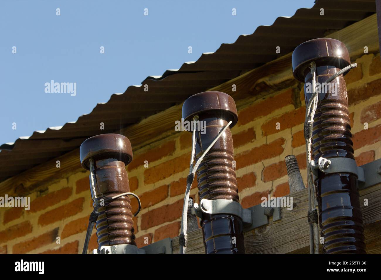 Three brown poles with black caps are on a roof. The poles are ...