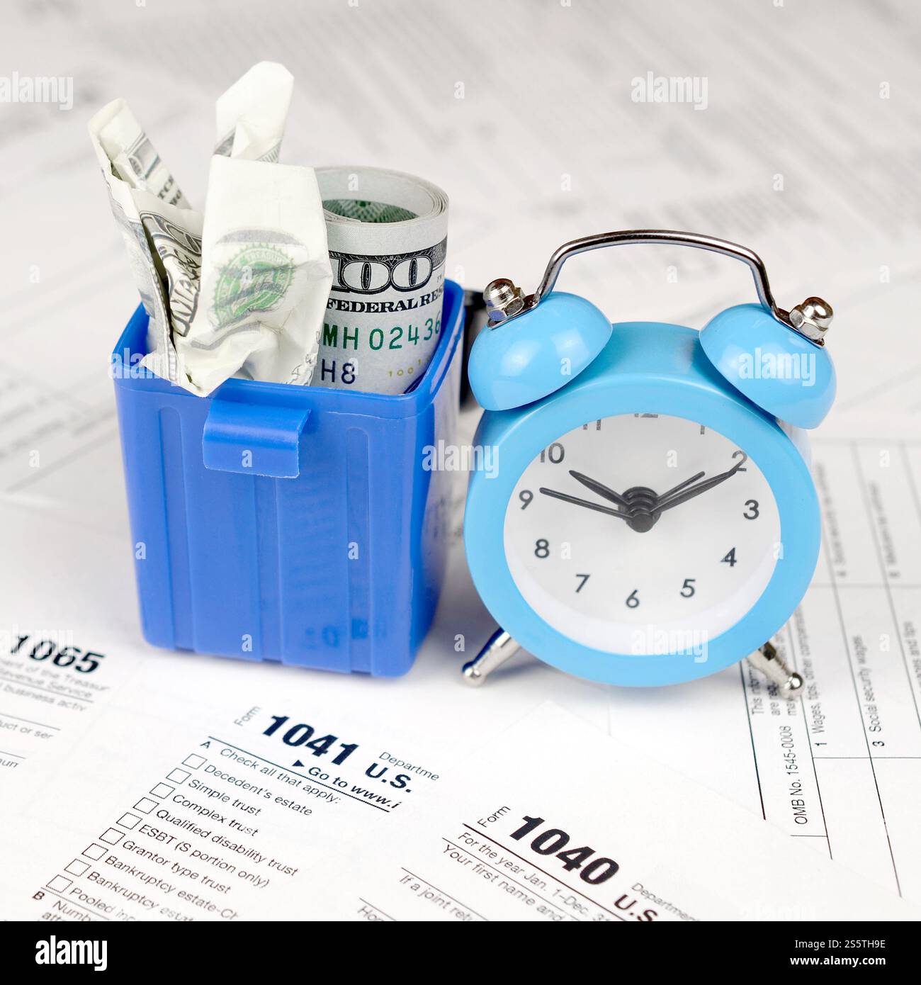 Many american tax blank forms with blue alarm clock and crumpled ...