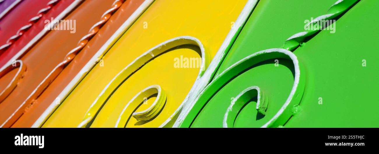 Metal texture of a piece of colored wall with a forged pattern. Rainbow ...