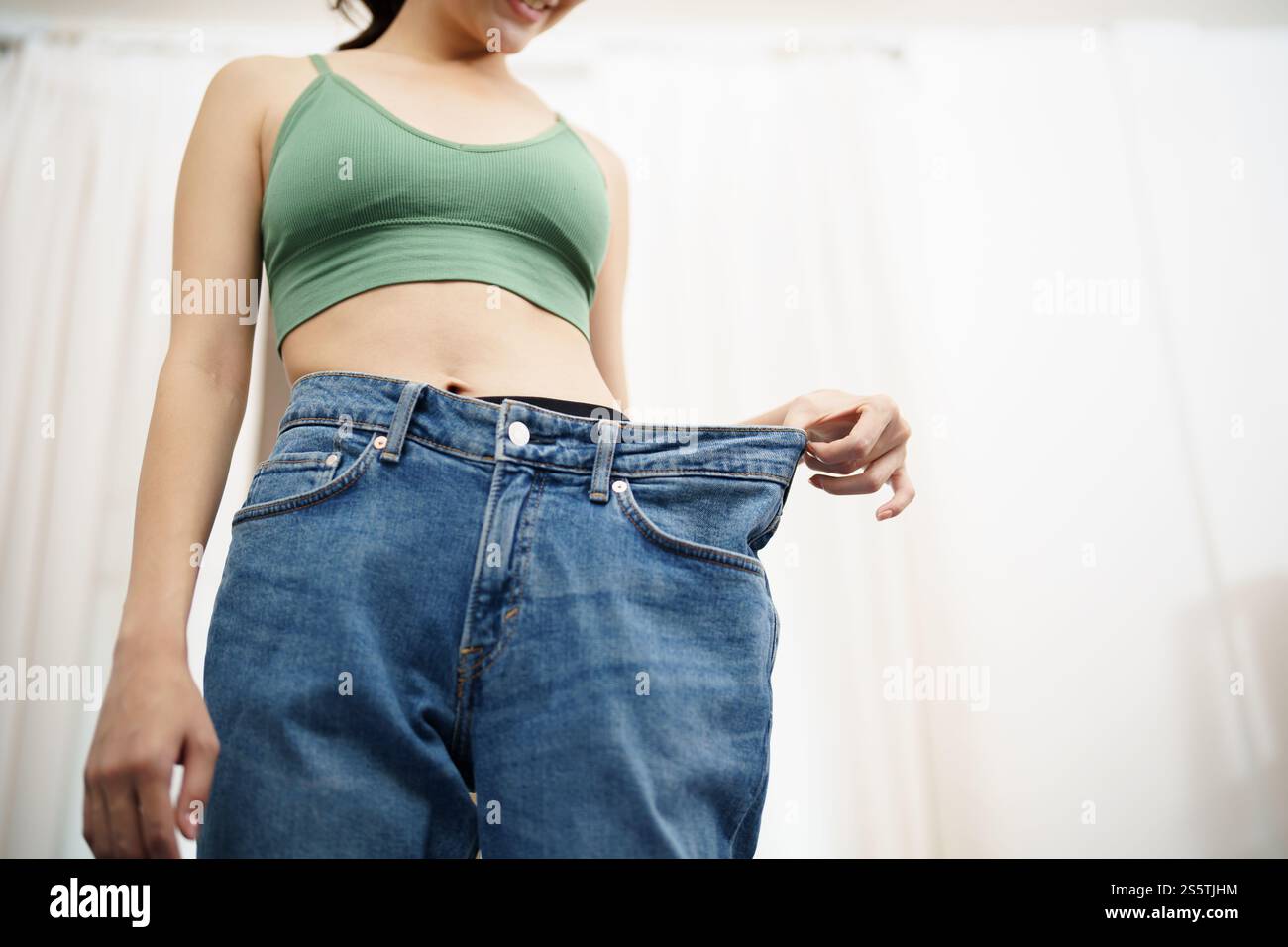 Asian woman dieting Weight loss. Slim woman in oversize jeans Stock ...