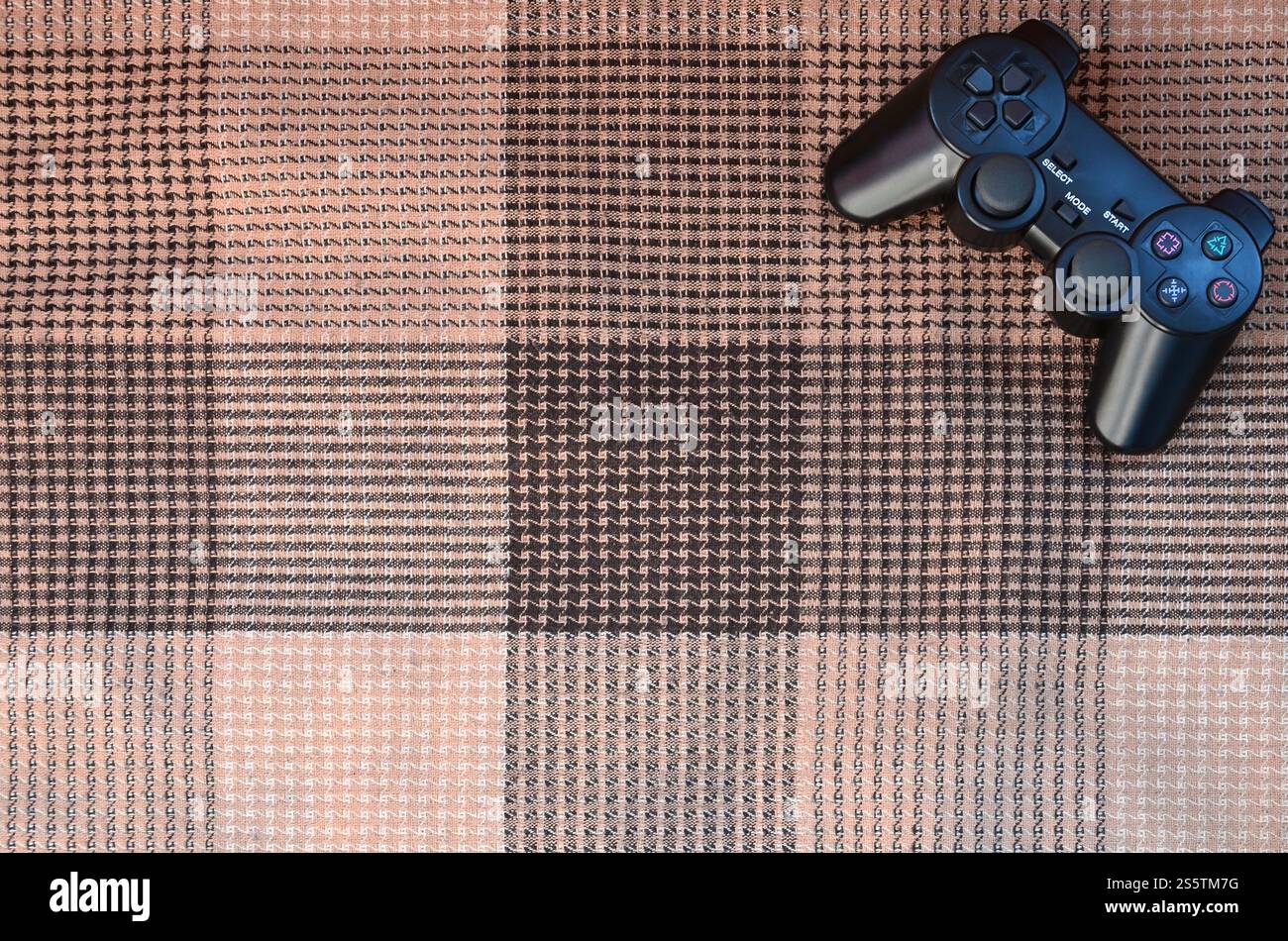 The video game controller from the game console is on the checkered ...