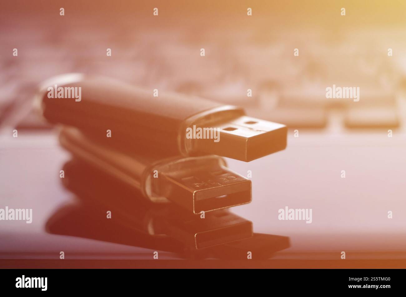 USB flash cards lying on black laptop case in front of his keyboard ...