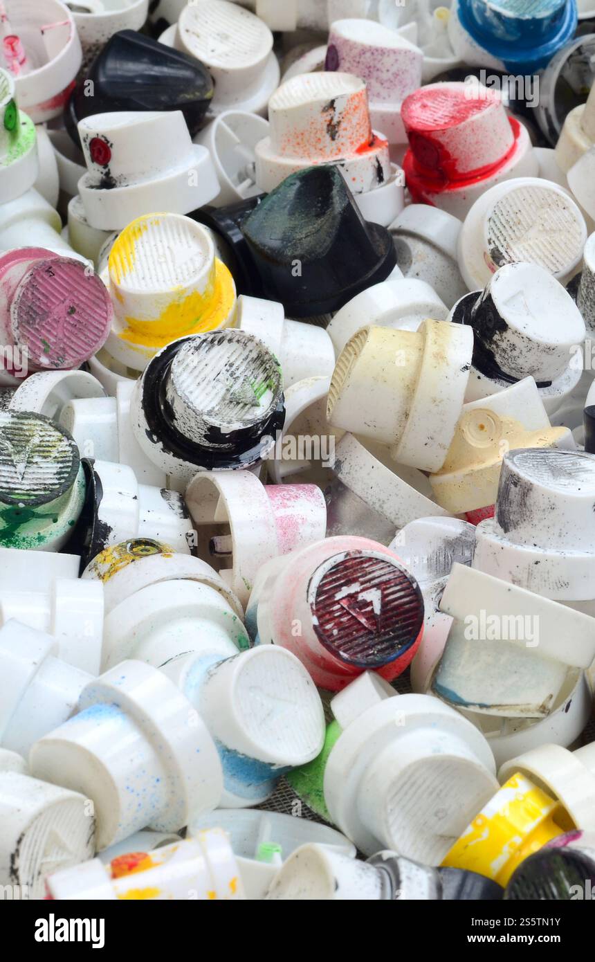 A large number of caps from cans of aerosol paint for graffiti. Smeared ...
