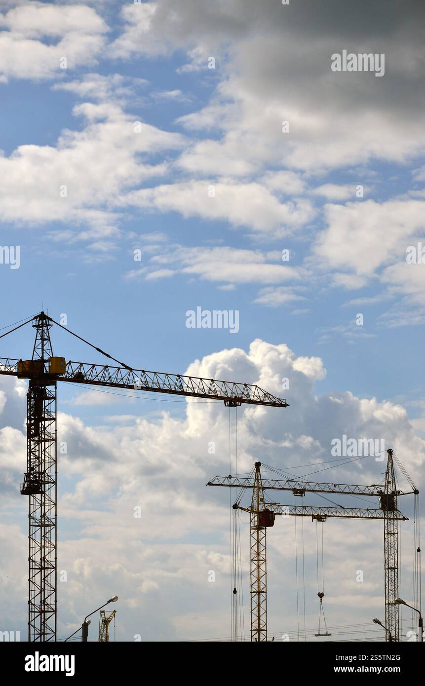 Tall and heavy construction crane towers against a blue sky Stock Photo ...