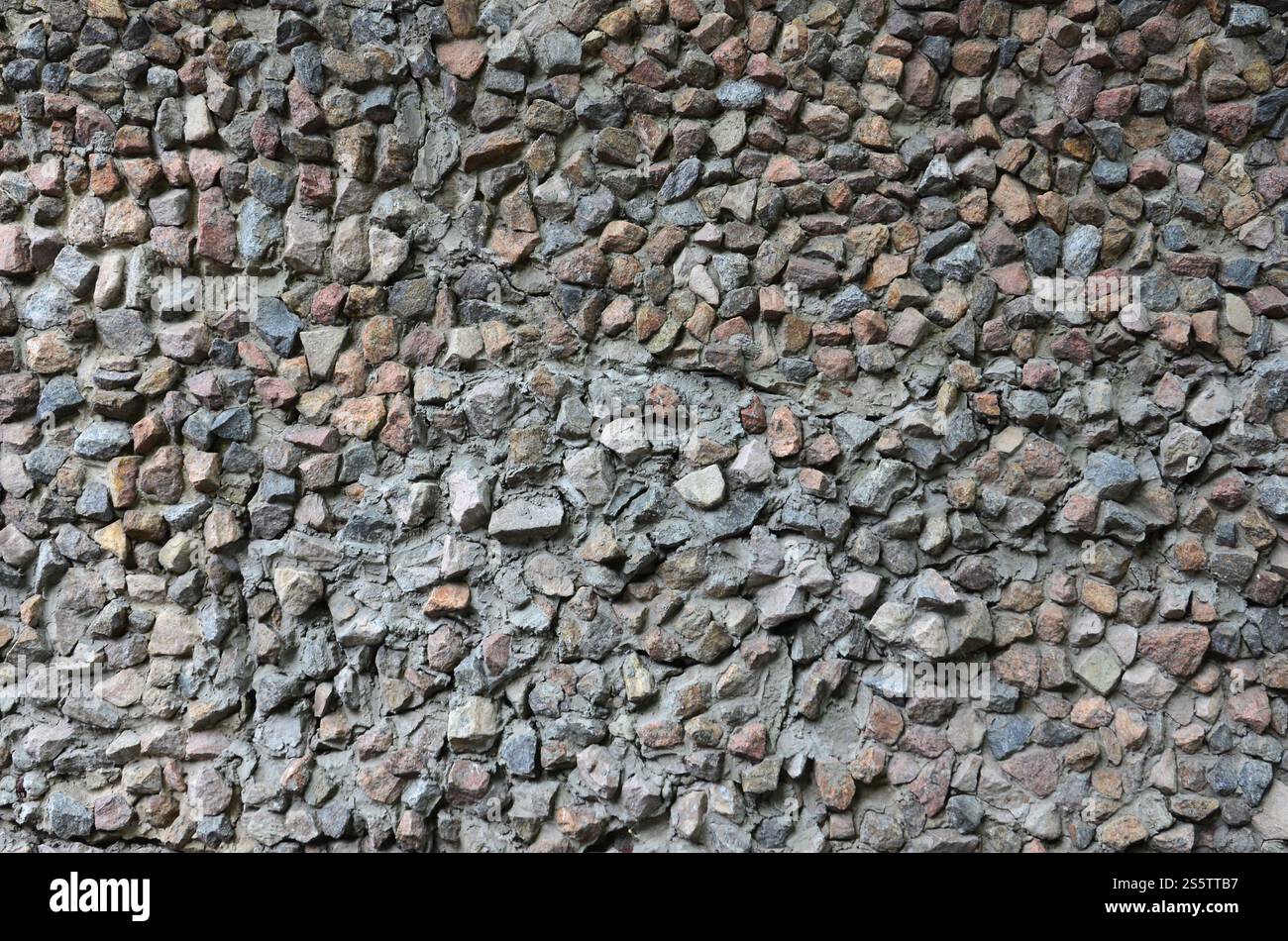 The texture of a strong stone wall of many concreted stones of various ...
