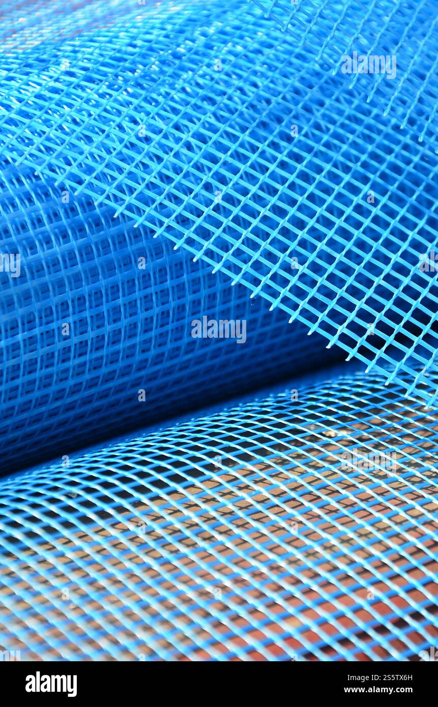 Close-up texture of a blue reinforcing mesh rolled up in a roll ...
