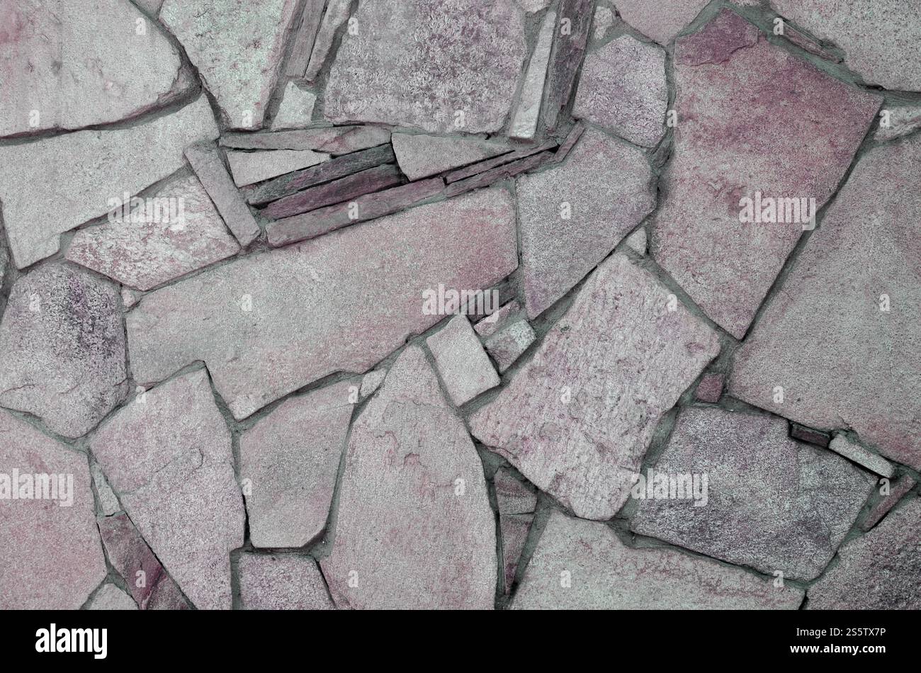 The texture of a strong stone wall of many concreted stones of various ...