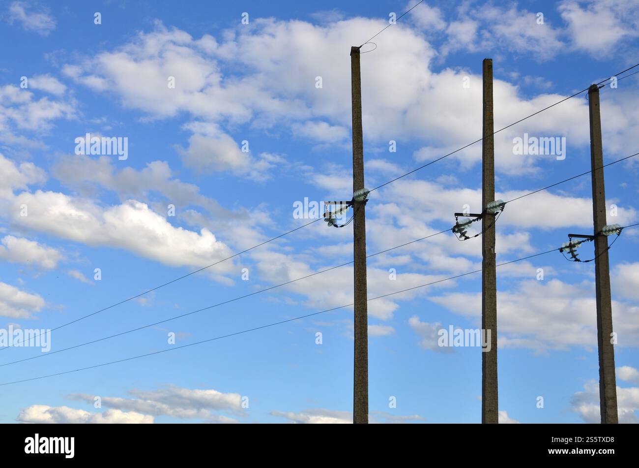Concrete pole with wires of power line against the background of blue ...