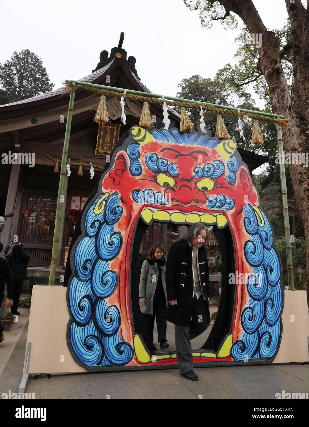 Visitors pass through the evil gate at Kamado Shrine in Dazaifu City ...