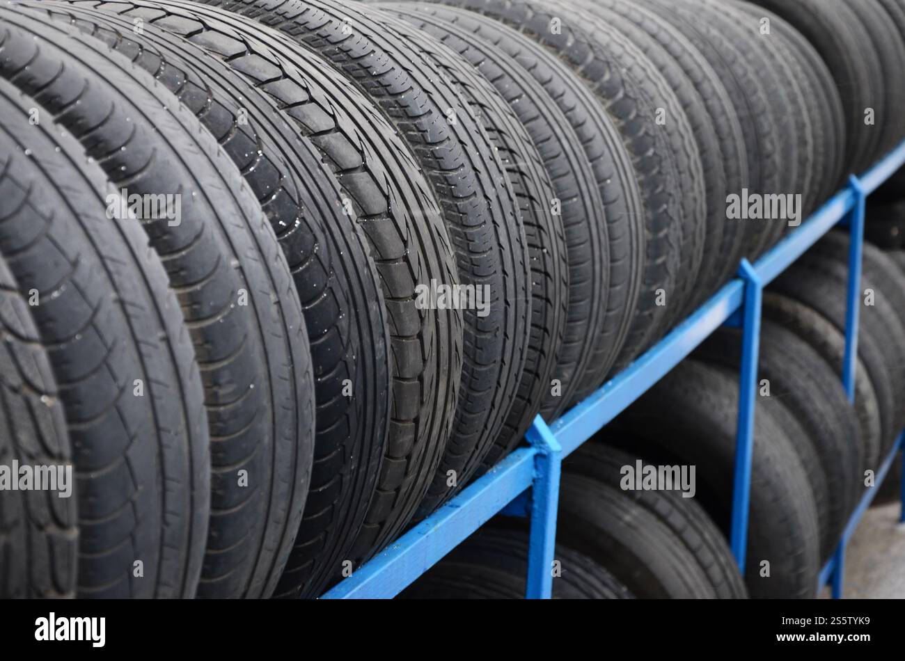 Rack with variety of car tires in automobile store. Many black tires ...