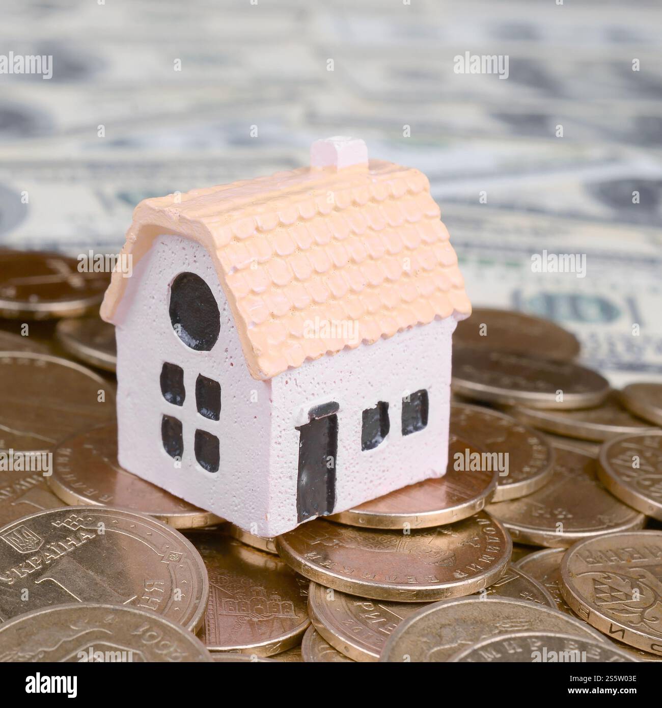 Mini house model on big coins stack on many dollar bills as background. Risk, Assets and ...
