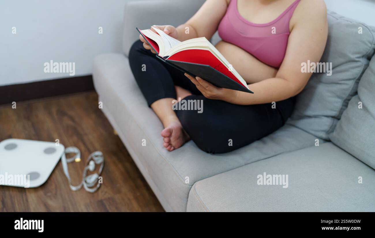 Overweight woman reading book for lose weight. Fat woman worried about ...