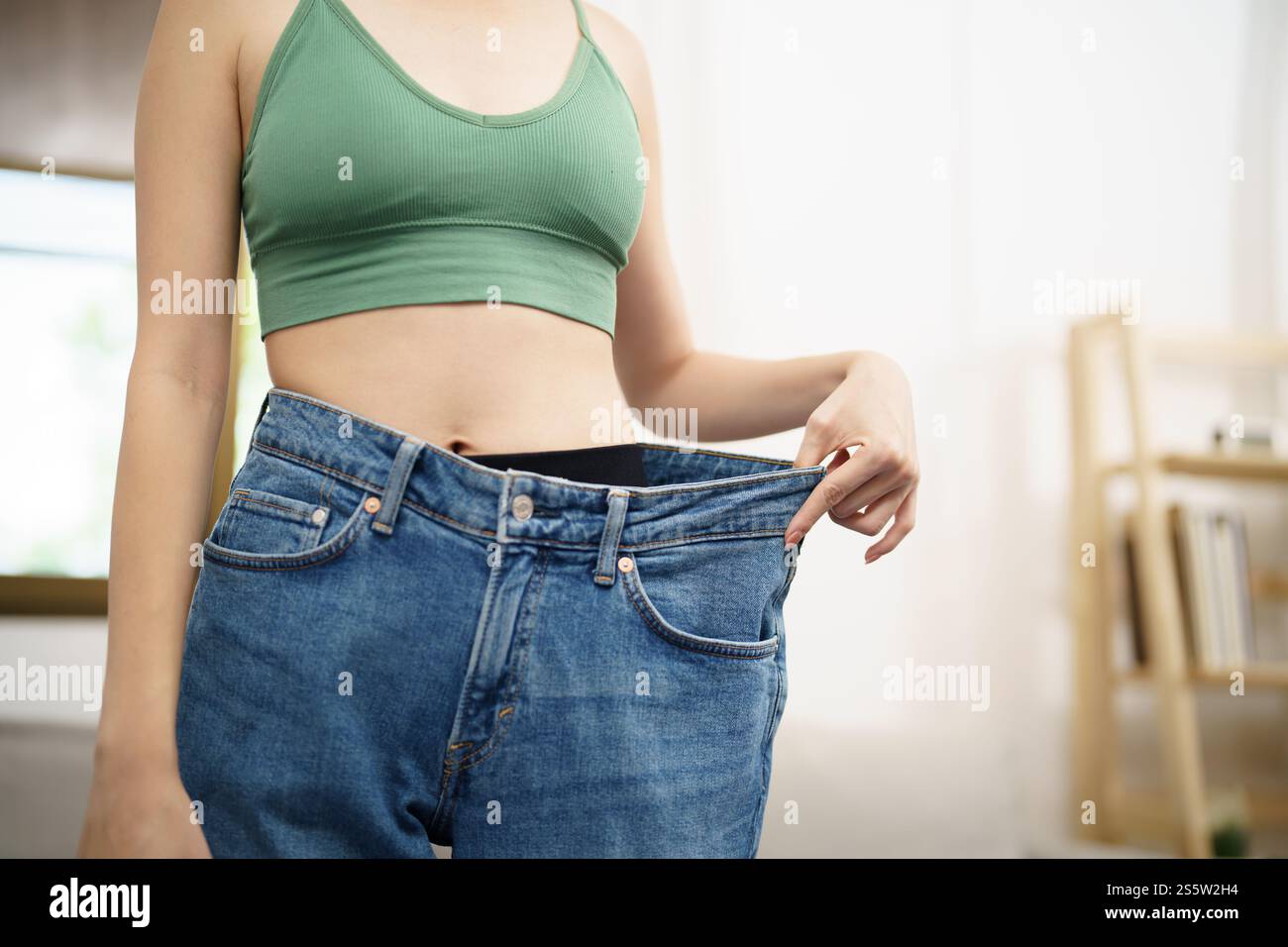 Asian woman dieting Weight loss. Slim woman in oversize jeans Stock ...